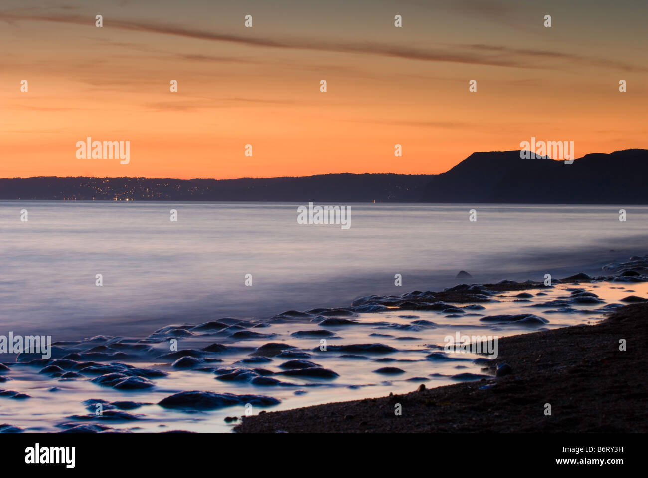 Sunset reflections in rock pools on the beach at Burton Bradstock ...