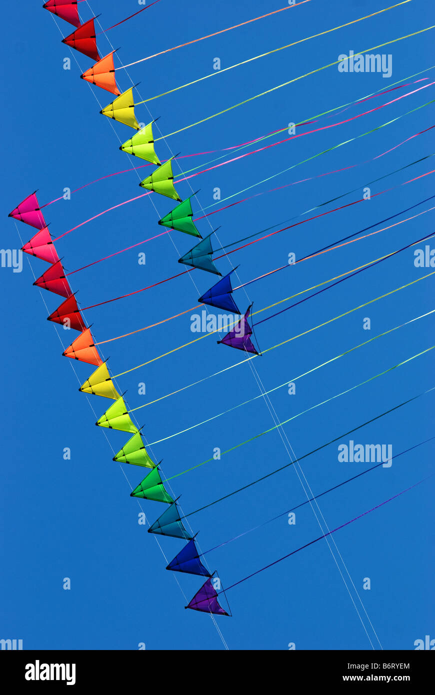 Two stacks of stunt kites in rainbow colours on a blue sky background ...