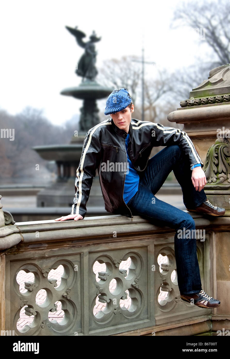 Handsome caucasian guy sitting on railing with angel background Stock ...