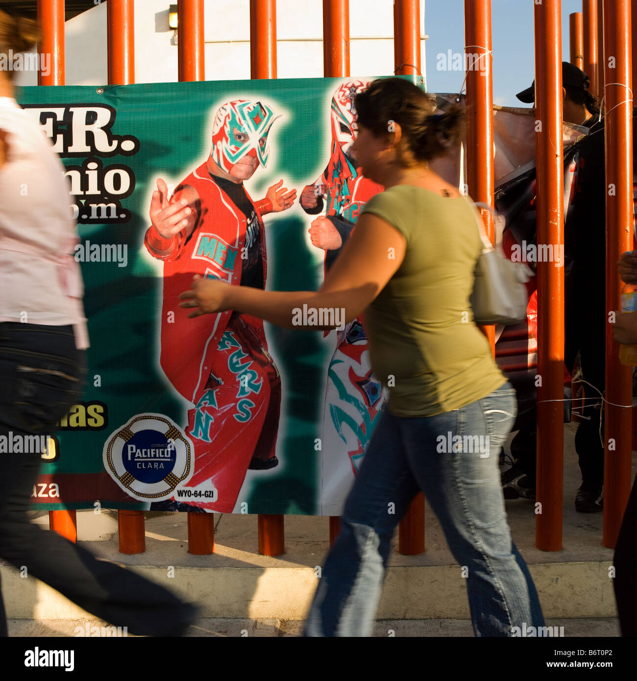 woman mexican mexico walking past lucha libre poster Stock Photo - Alamy