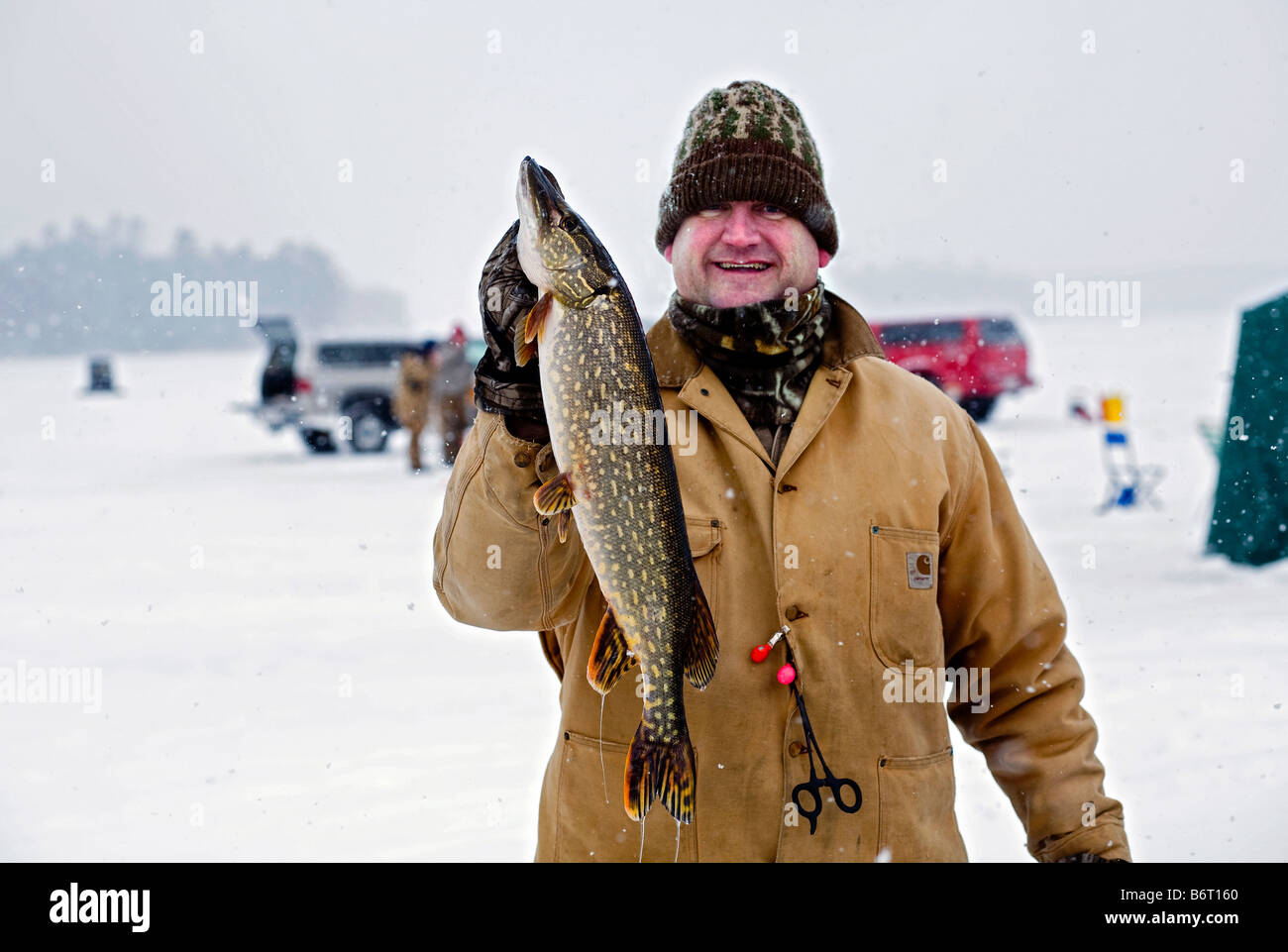 Showing off a Northern Pike caught during an ice fishing tournament in ...