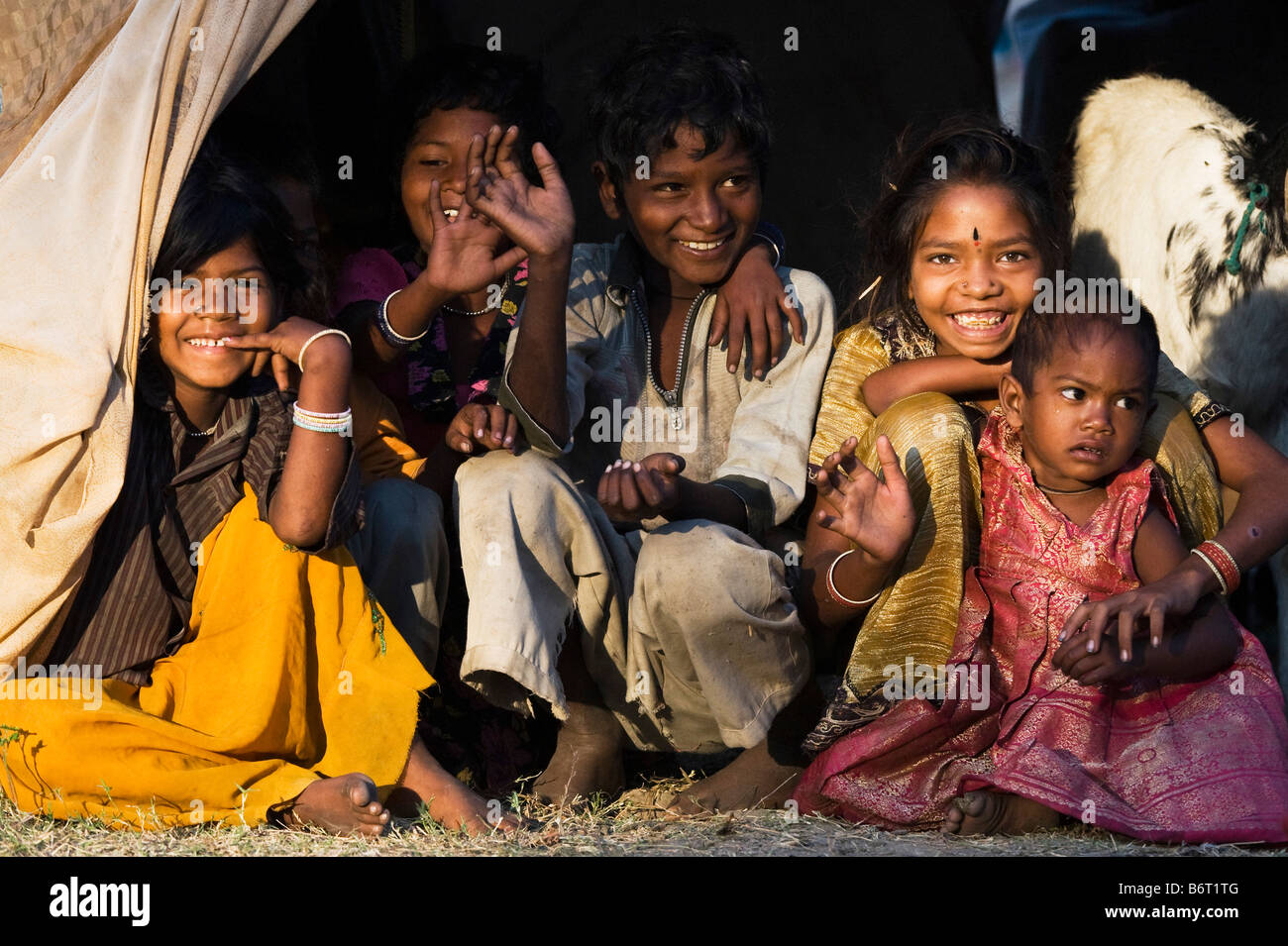 Poor Indian children sitting in their tent home in the morning light ...