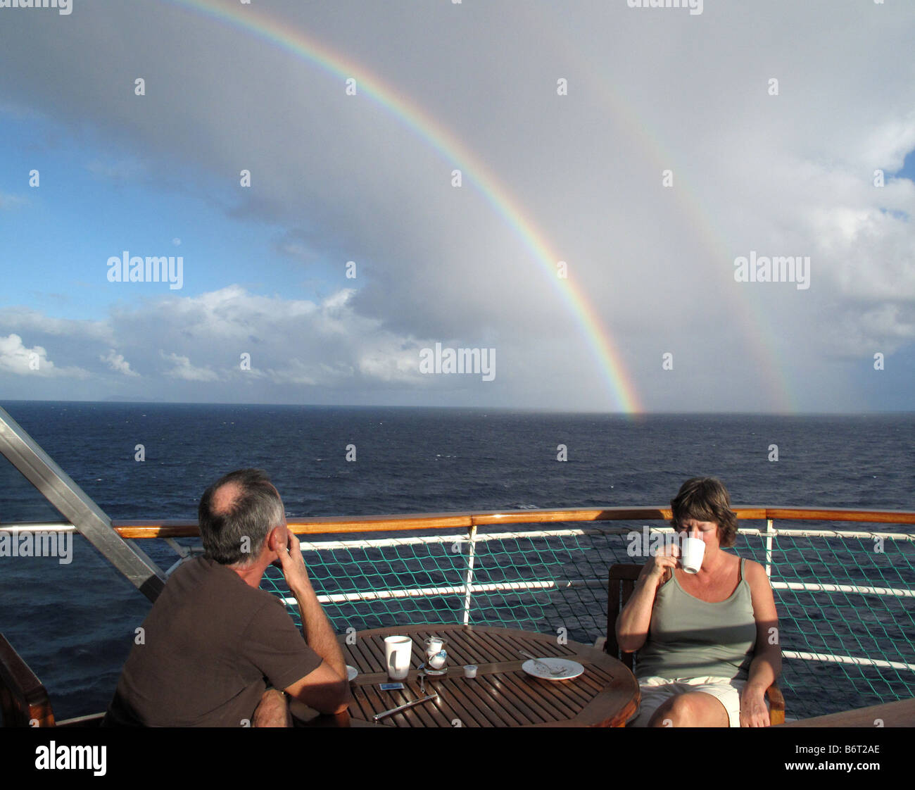 A couple drink afternoon tea on a cruise ship in the Caribbean with a ...