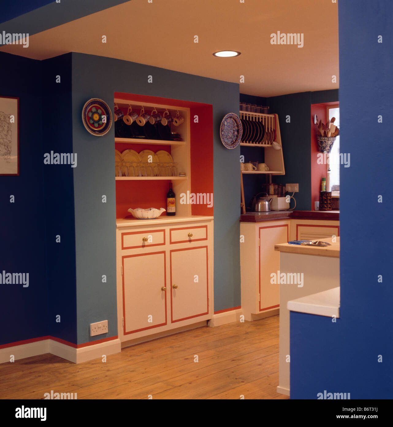 Fitted dresser in blue and red economy style kitchen with wooden ...