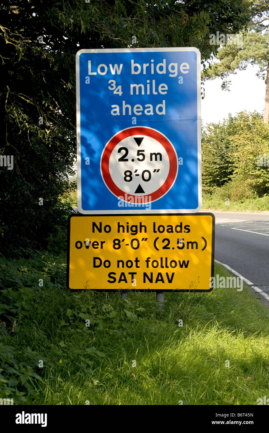 Road sign warning of a low bridge ahead and instructing not to follow ...