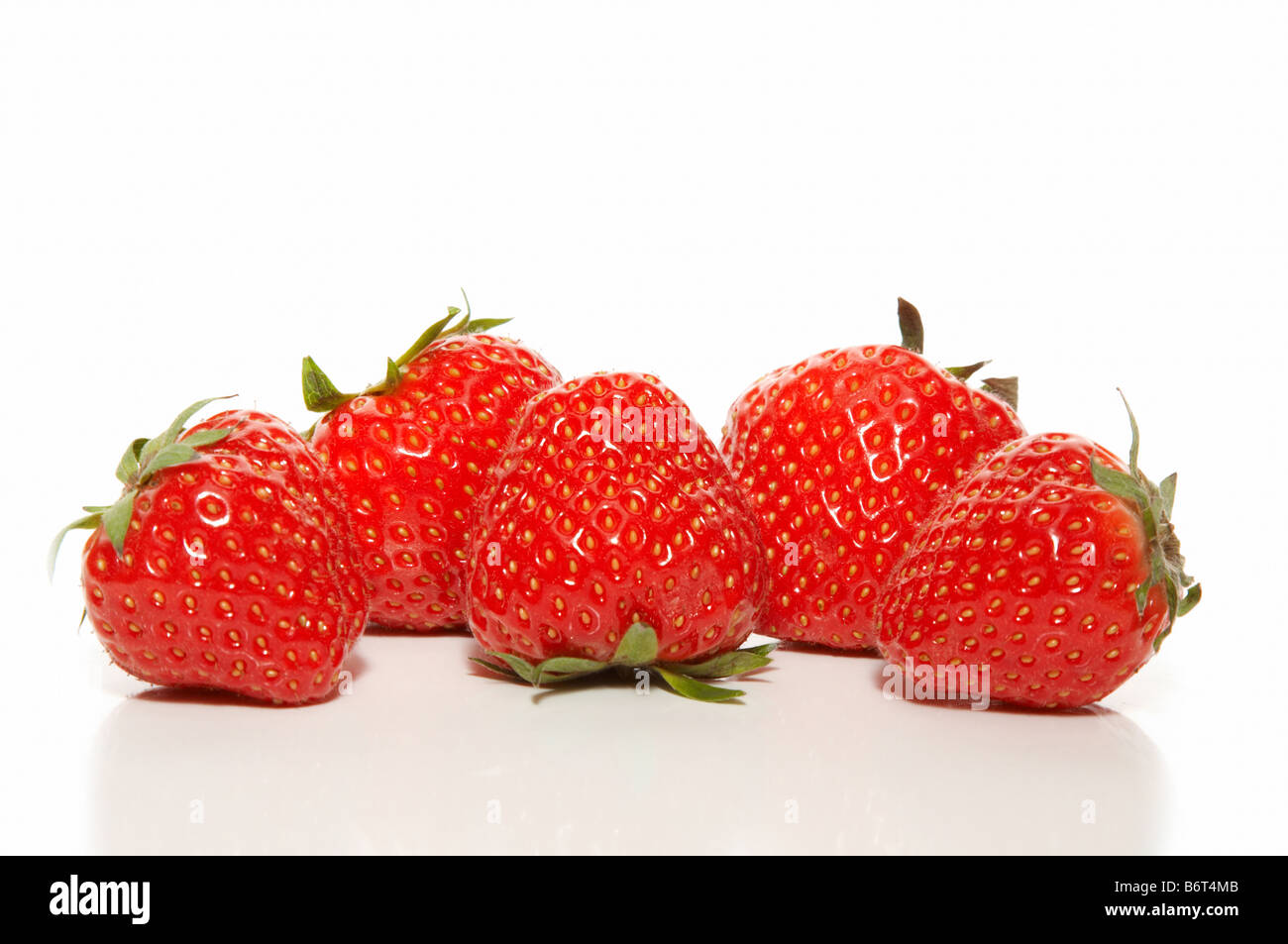 five strawberries in a row Stock Photo - Alamy