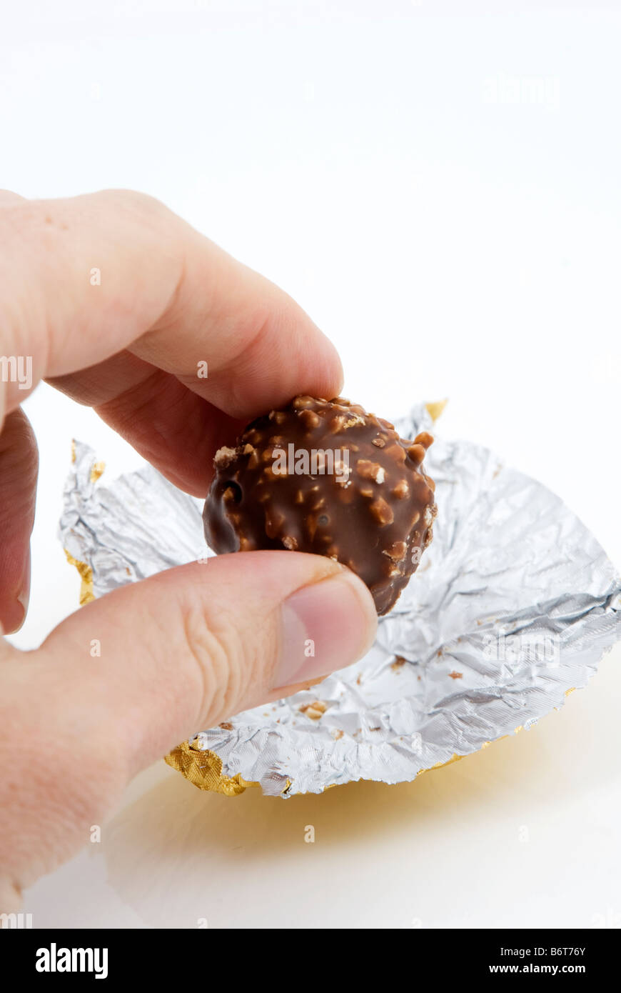 hand picking up a chocolate Stock Photo - Alamy