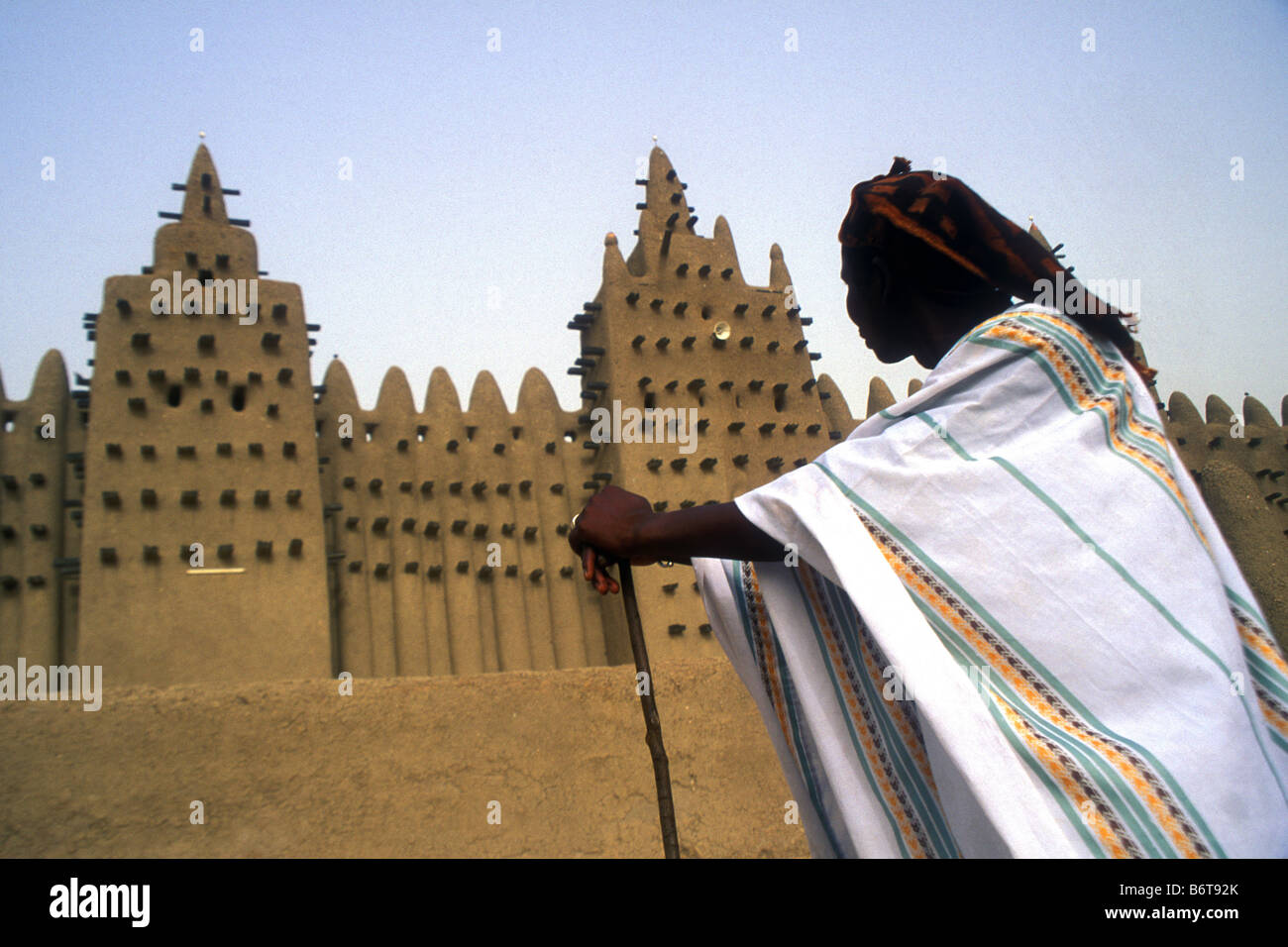 Man standing outside the mud mosque of Djenne Mali Stock Photo - Alamy