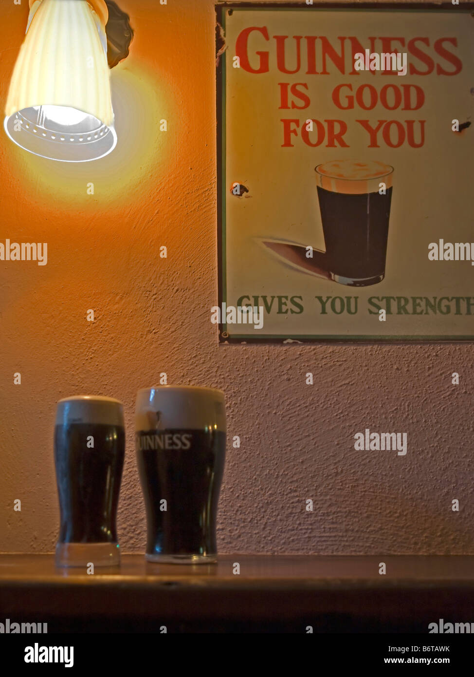 two glasses of Guiness beer on table bar in front of nostalgic ...