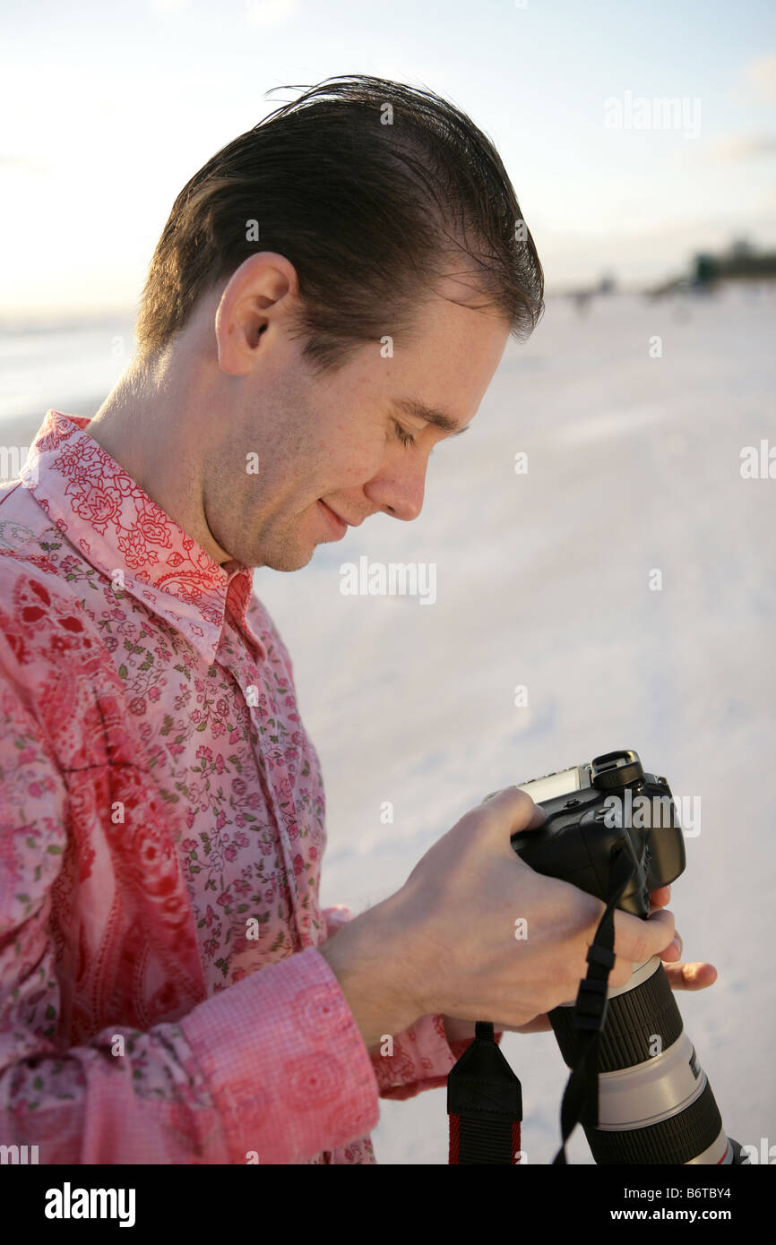 A photographer reviewing his photos on the camera s LCD screen Stock ...