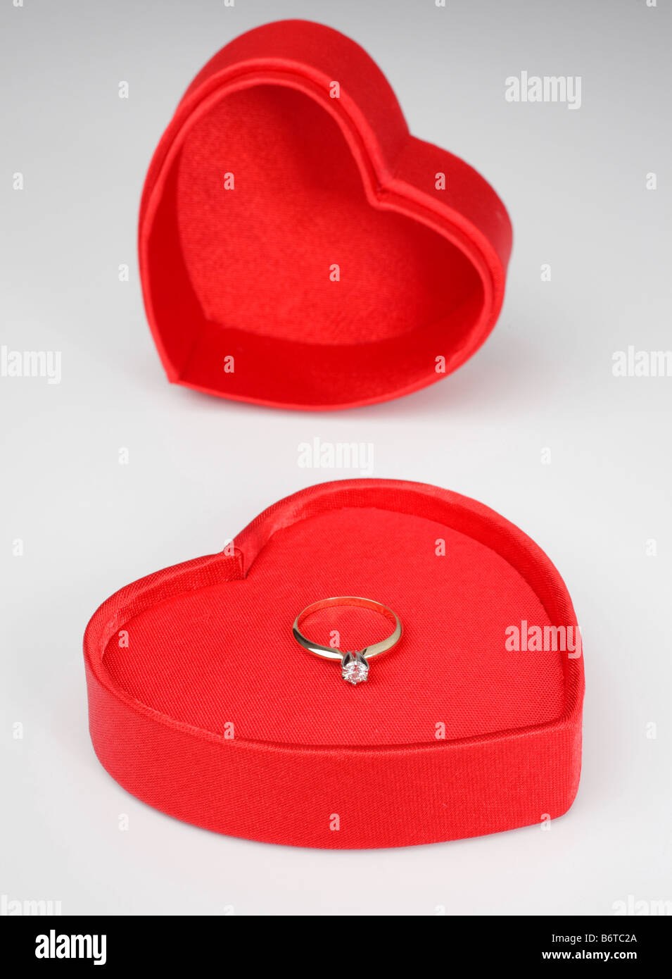 heart-shaped valentines day box with lid off and diamond ring inside on ...