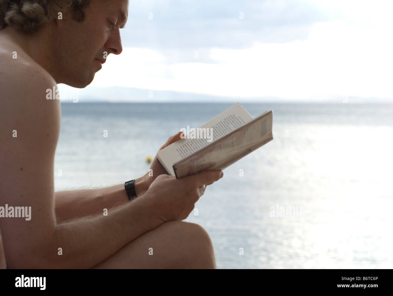 man reading on beach in greece Stock Photo - Alamy