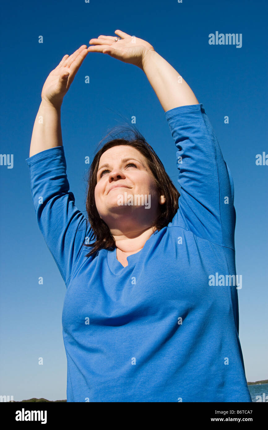 Plus sized woman doing yoga outdoors and offering praise Stock Photo ...