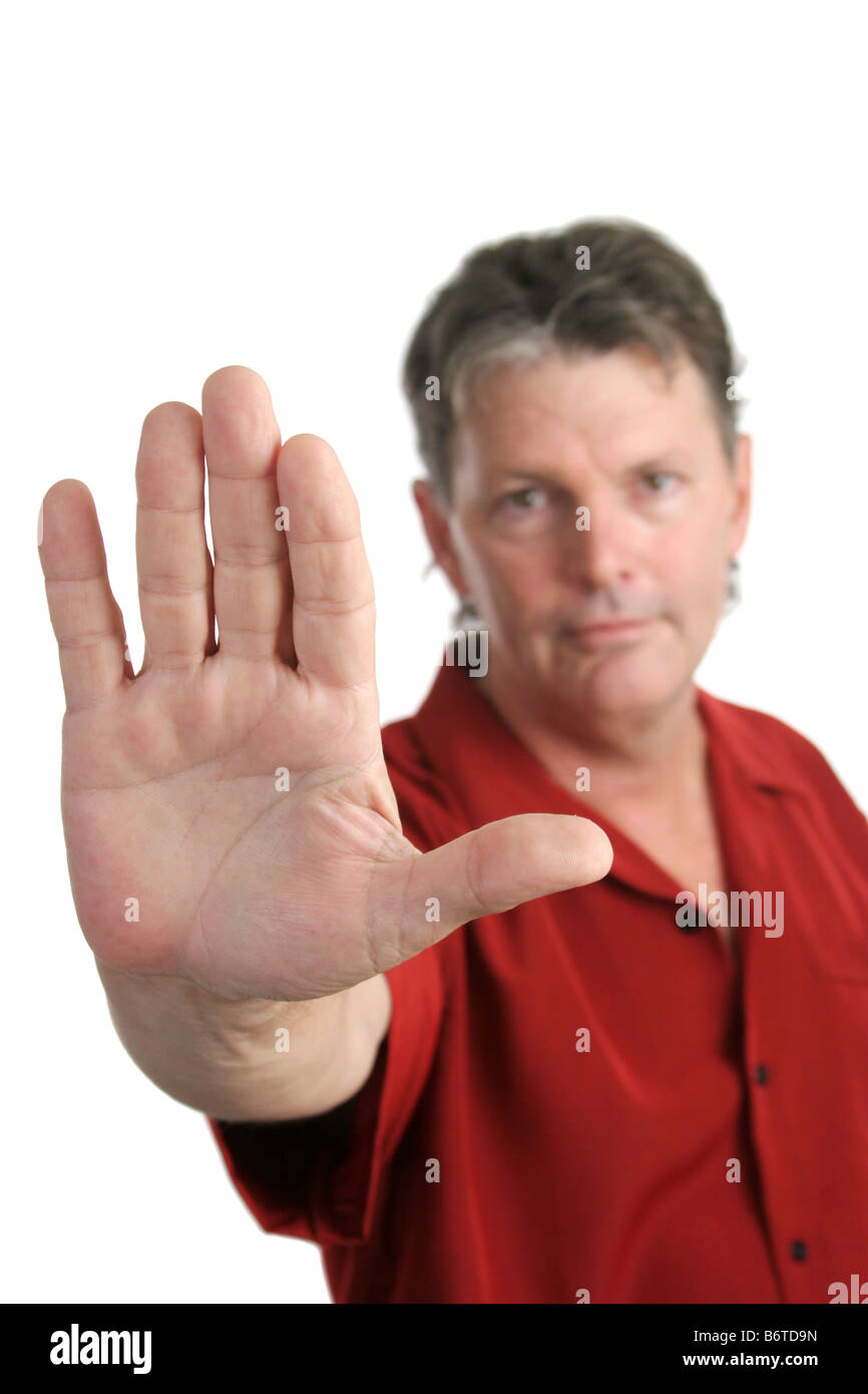 A handsome serious man holding his hand up in a stop gesture Focus on ...