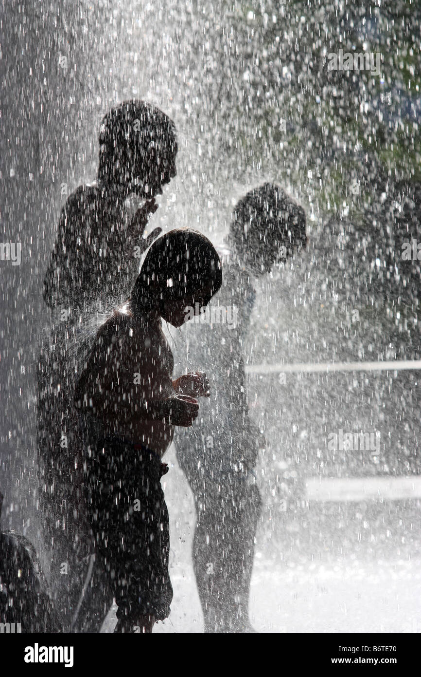 Three boys cooling off in water fountain Stock Photo - Alamy
