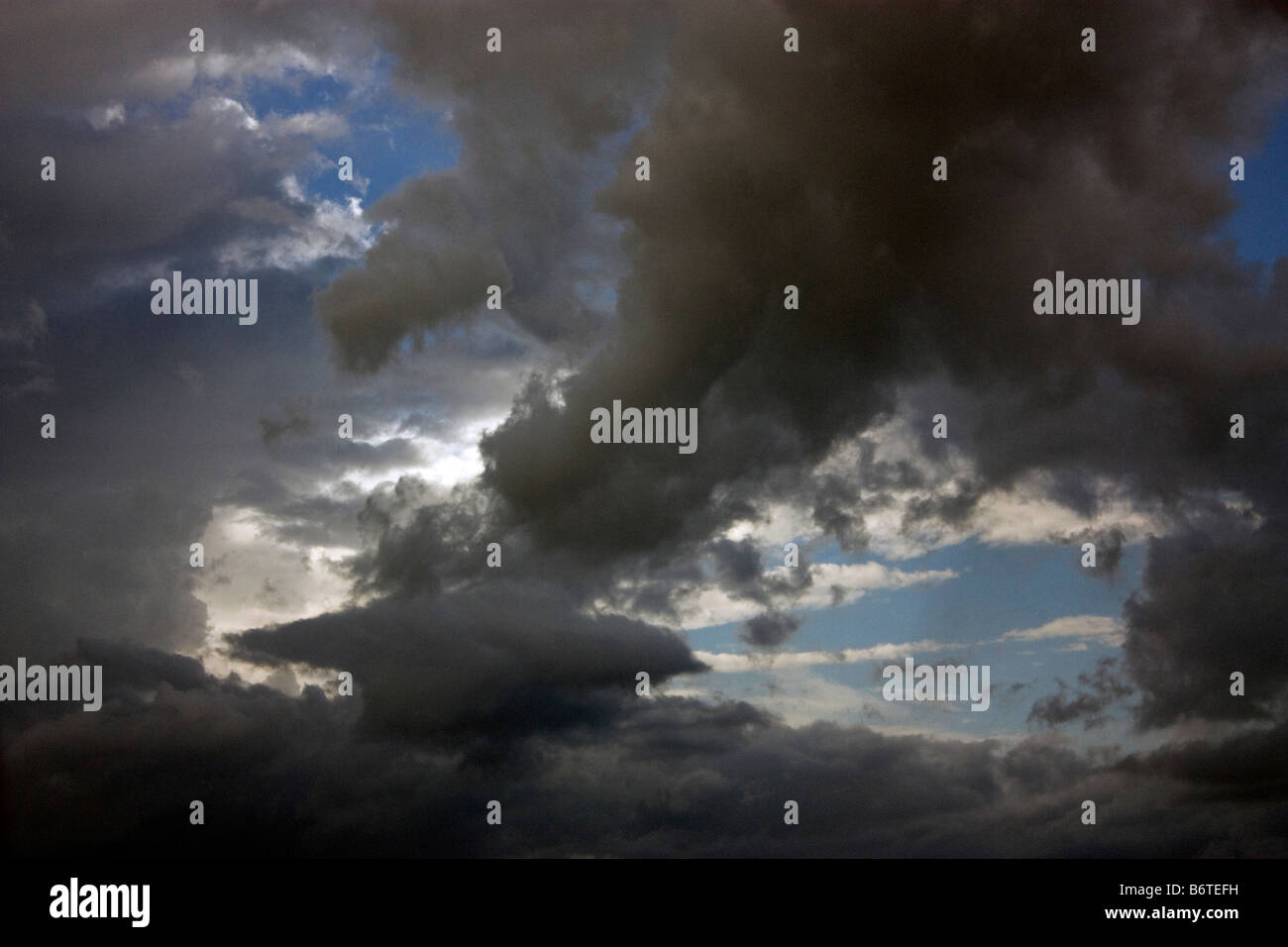 Dramatic Dark Clouds with Breaks of Blue Sky at Sunset Stock Photo - Alamy