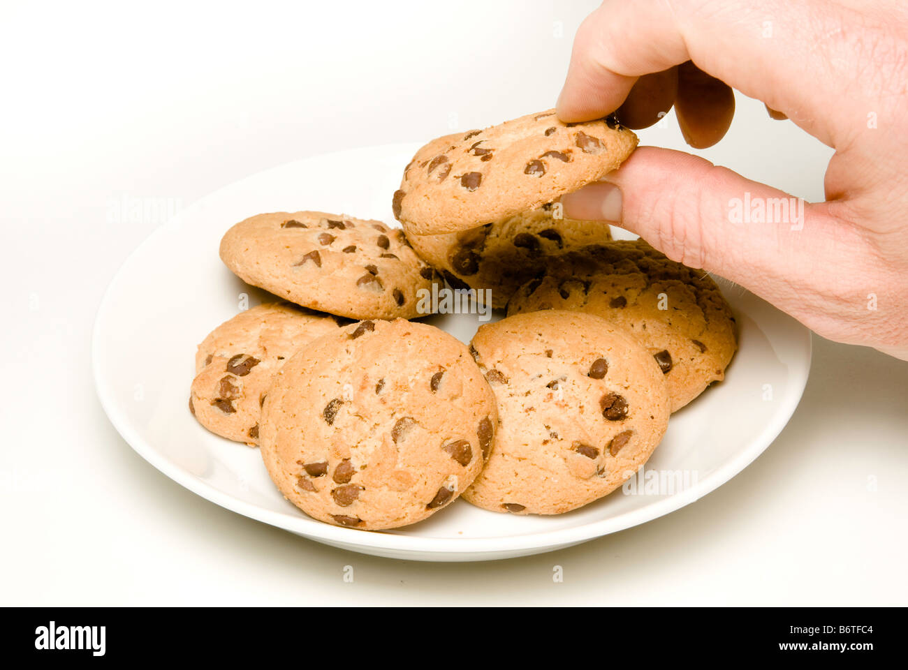 Hand taking a cookie from a plate Stock Photo - Alamy