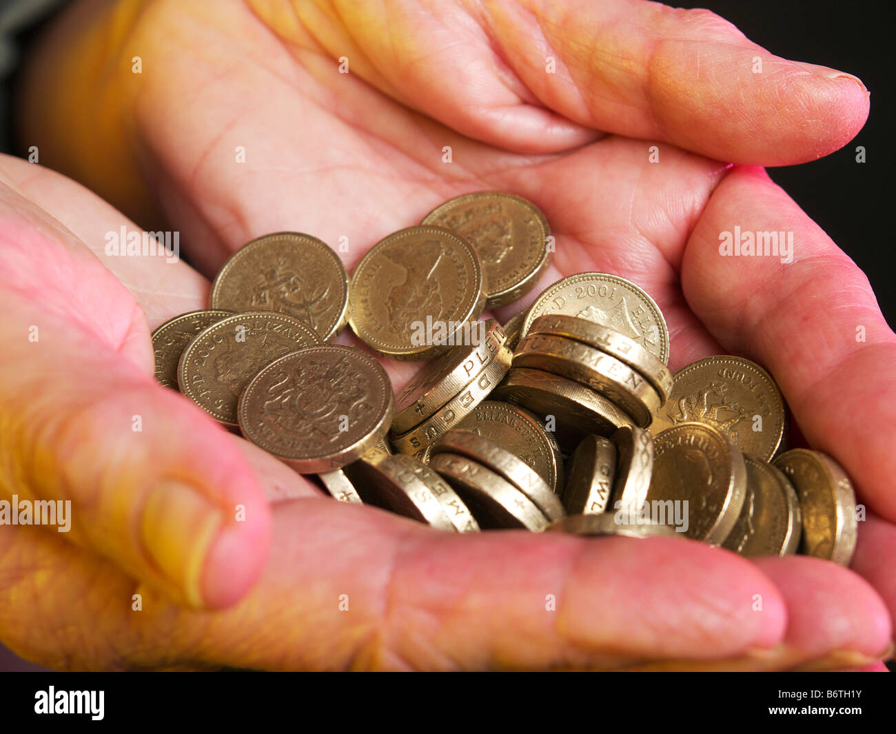 Young man holding both hands out with pound coins in both hands Stock ...