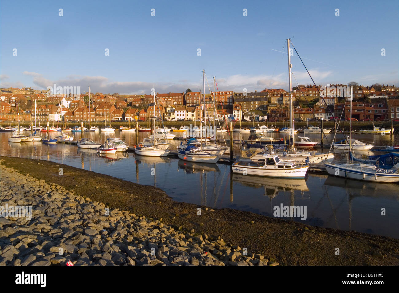 Whitby marina with small pleasure craft lit by winter afternoon sun ...