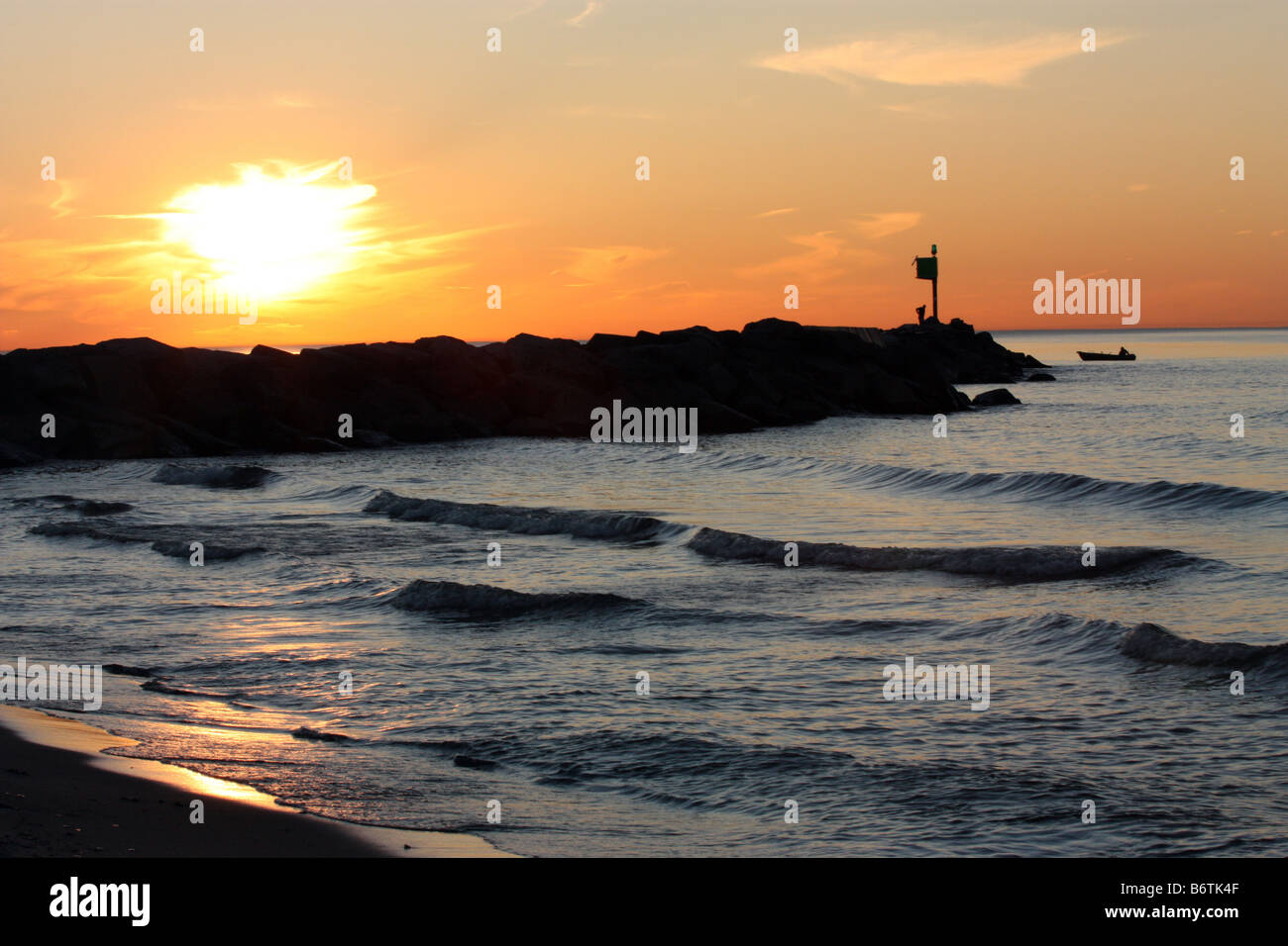 Breakwater in New Buffalo Michigan at sunset with small boat in ...