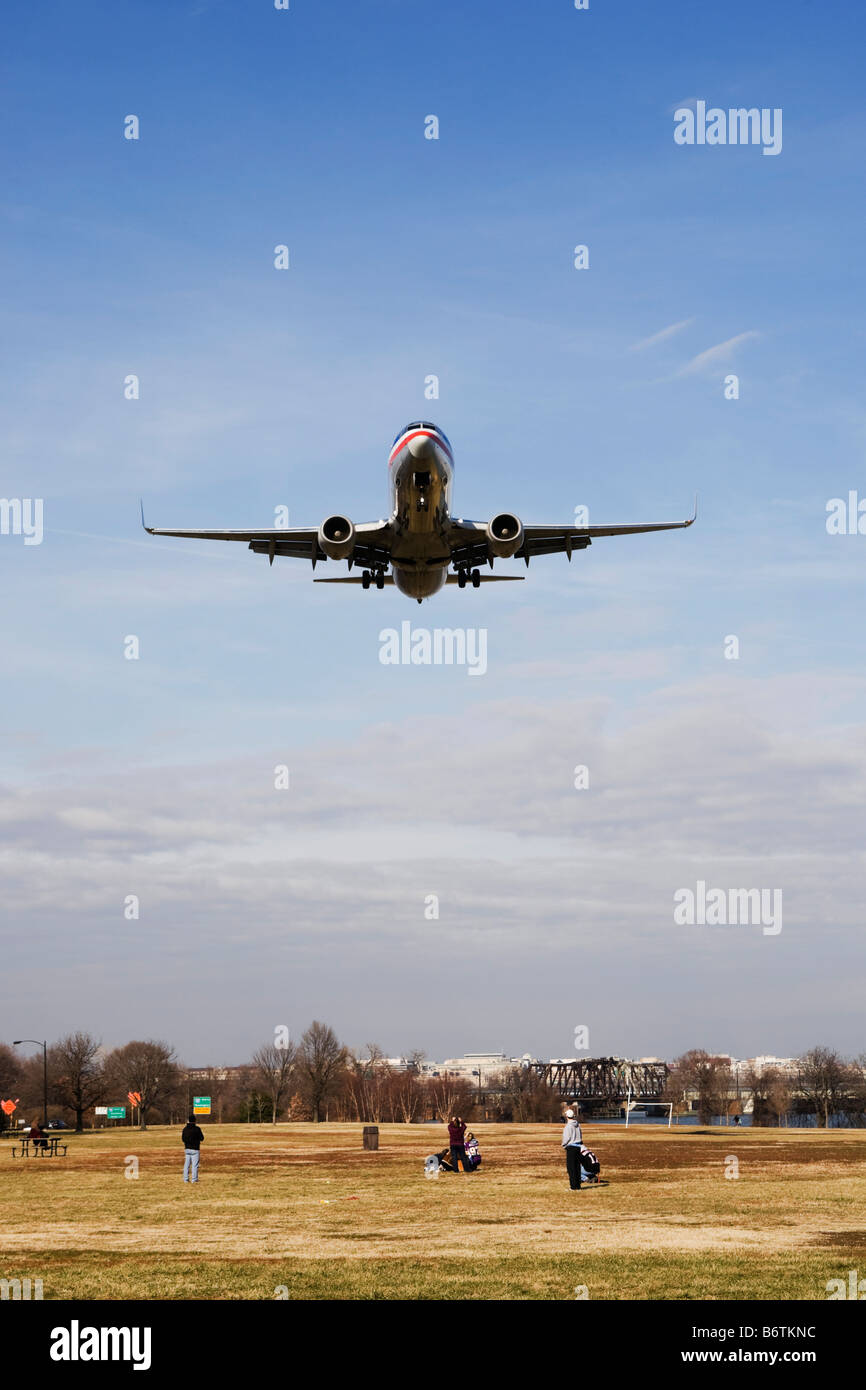 A commuter airplane flying over a city park Stock Photo - Alamy