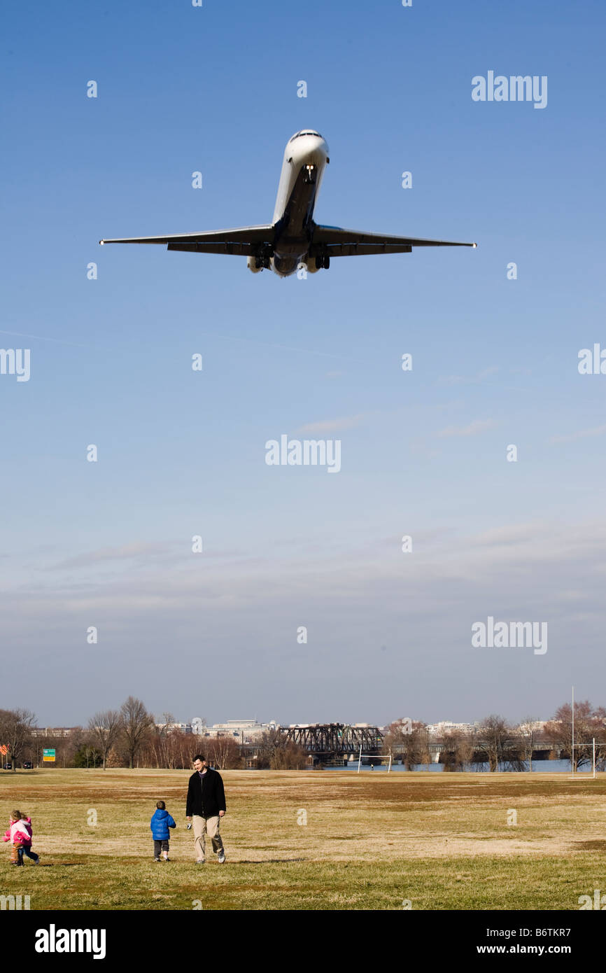 Plane flies over a city park Stock Photo - Alamy