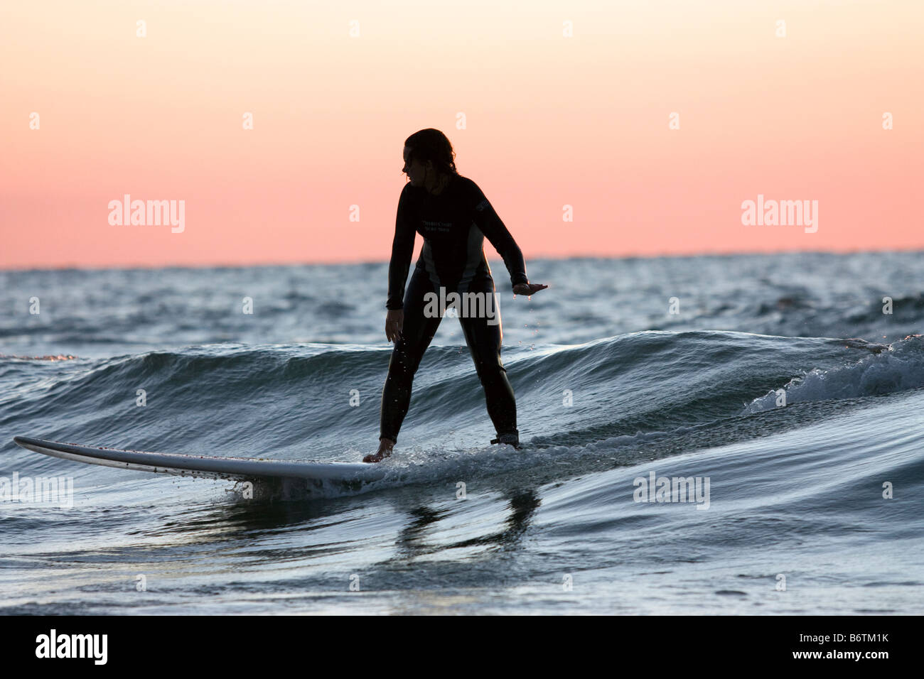 Surfer girl riding a small wave on Lake Michigan Stock Photo - Alamy