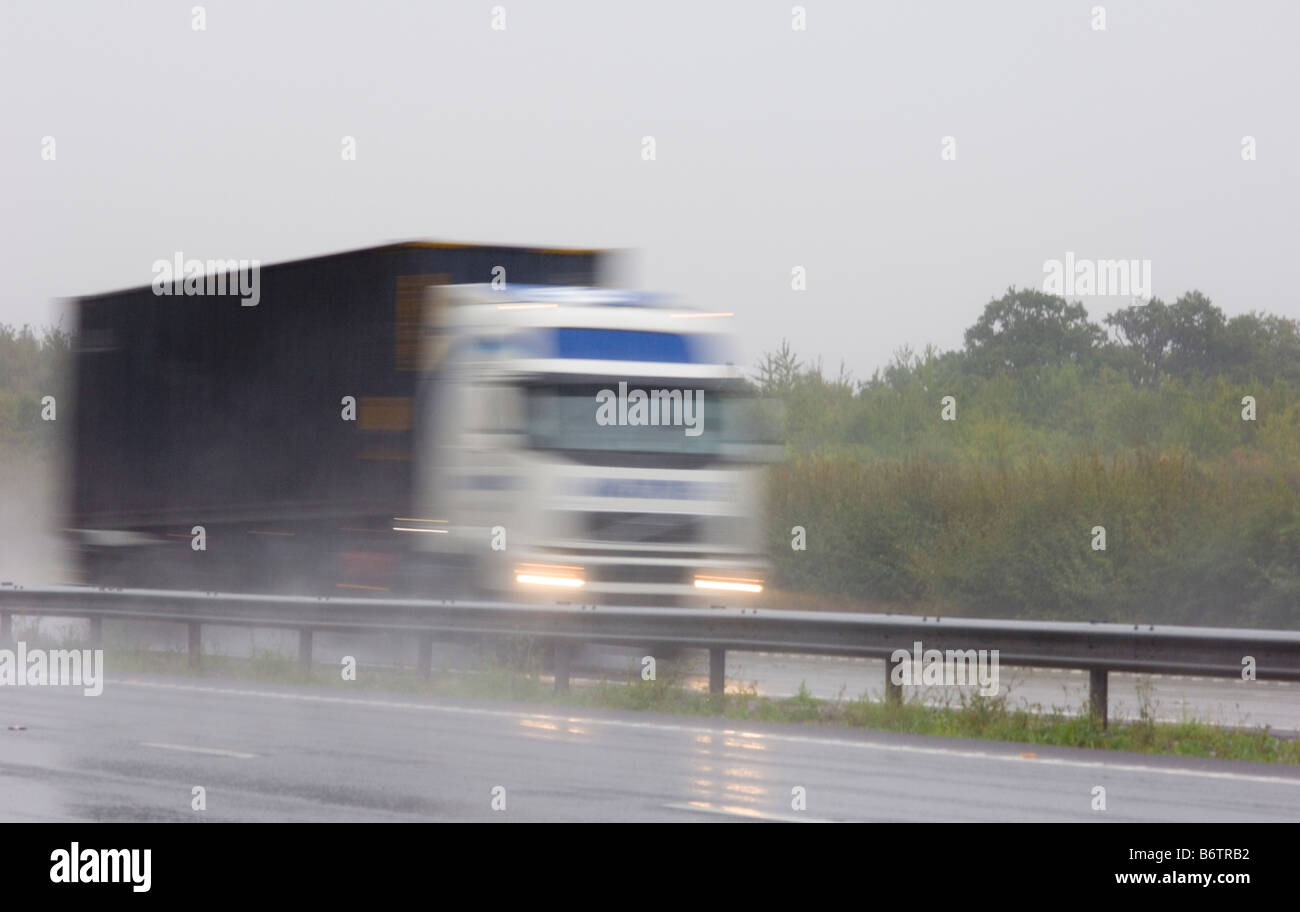 Lorry traffic in heavy rain on a dual carriageway road the A35 in ...