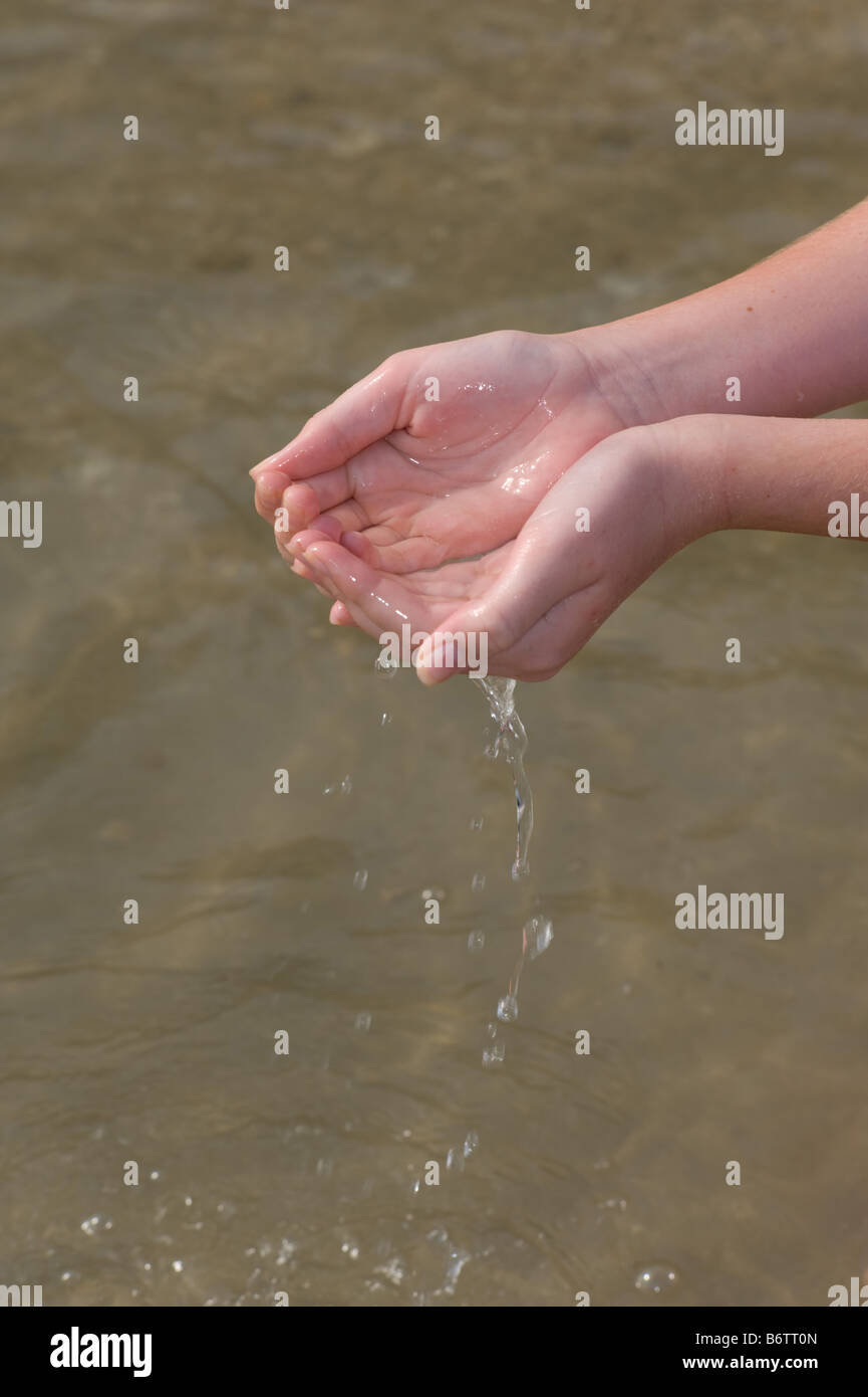 Water passing through a childs hands at beach Stock Photo - Alamy