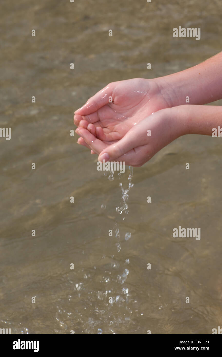 Water passing through a childs hands at beach Stock Photo - Alamy