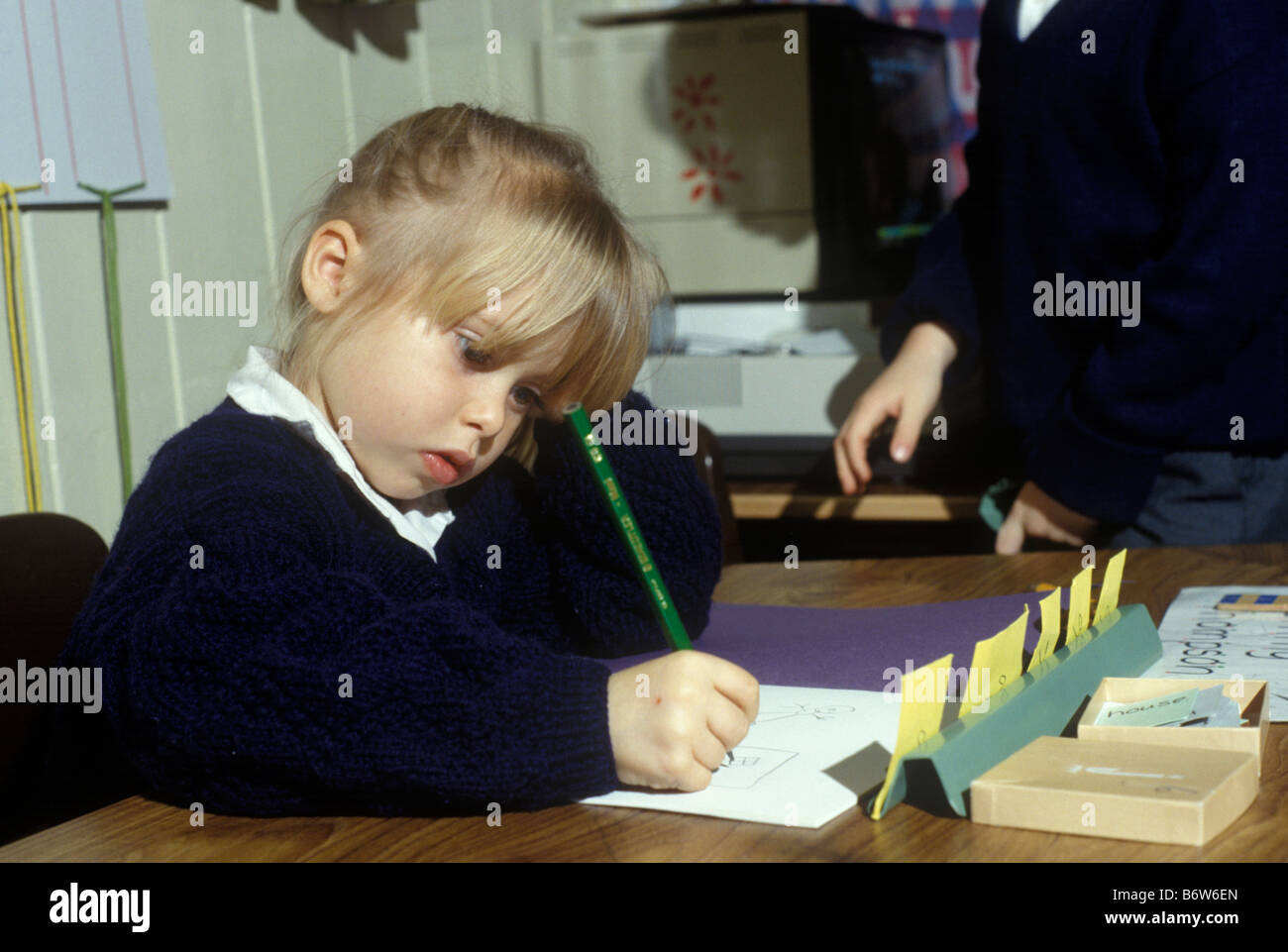 little girl writing in class using flash cards Stock Photo - Alamy