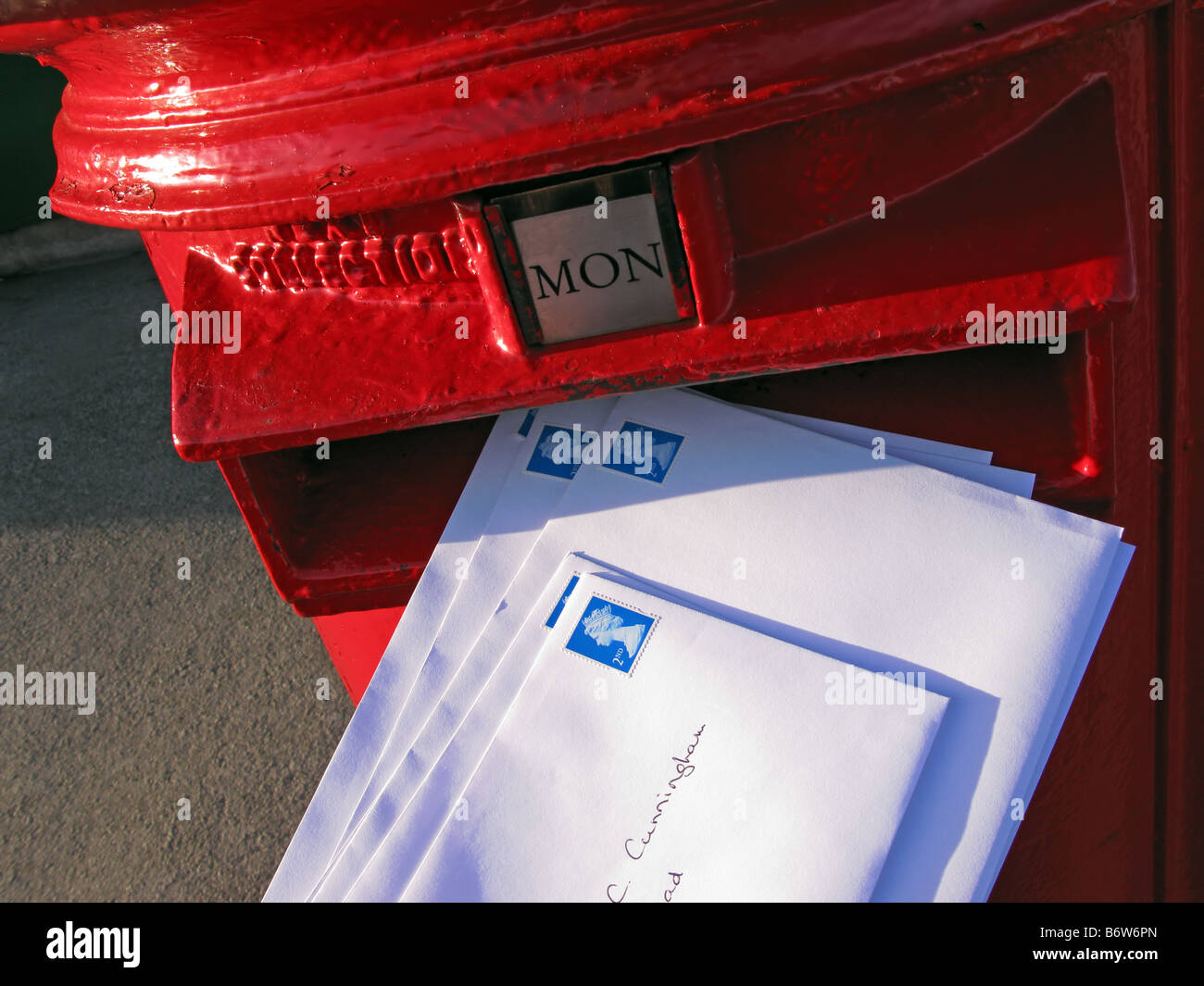 Posting envelopes in red letterbox Stock Photo - Alamy