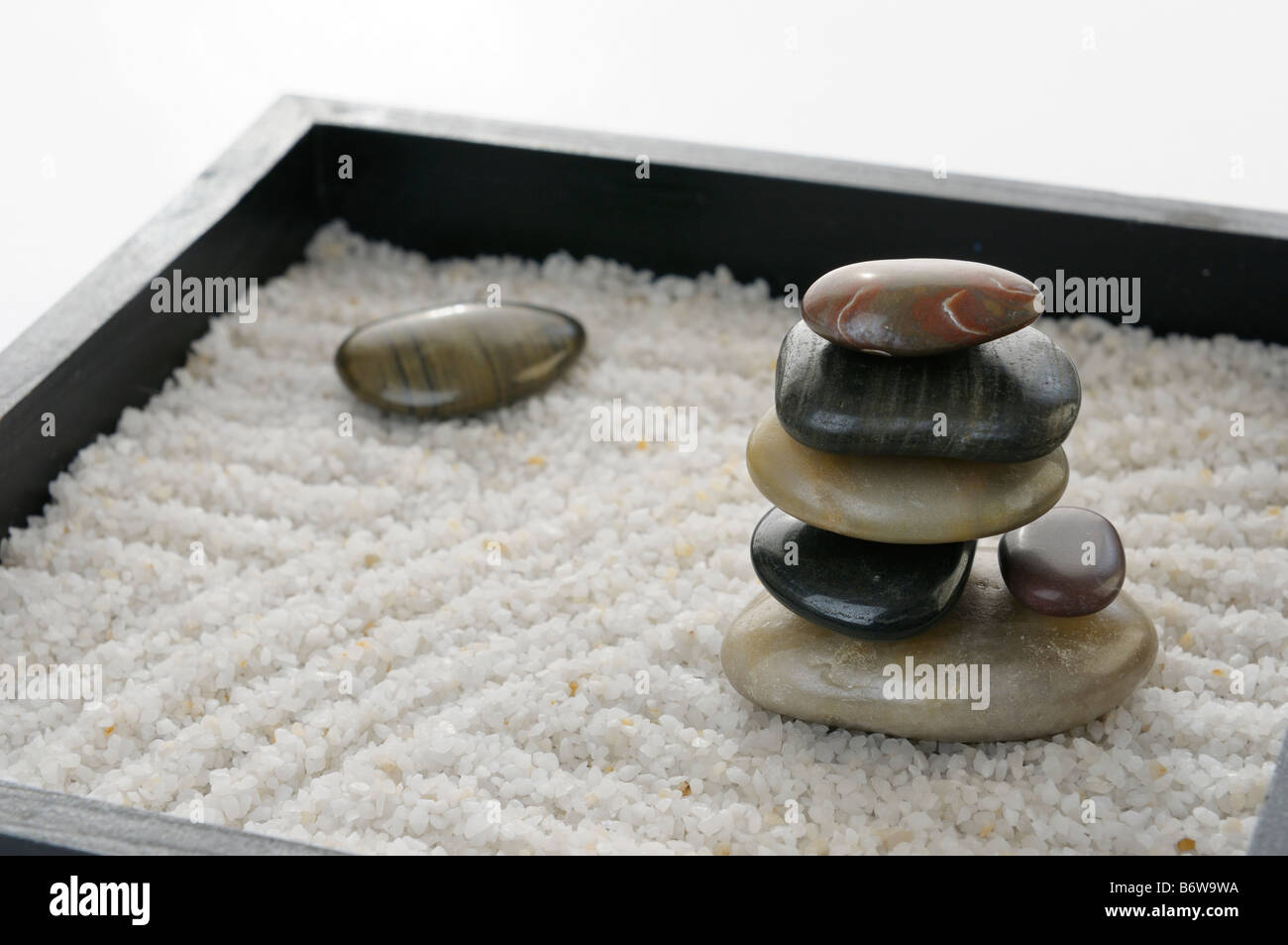 Stacked polished rocks in a miniature Zen rock garden sandbox Stock ...
