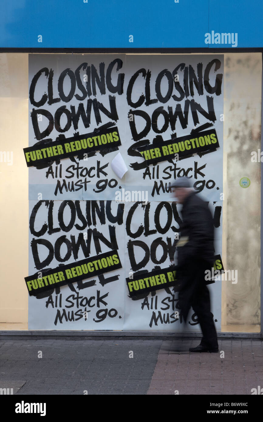 old man walking past closing down sale signs in a shop window in the uk ...