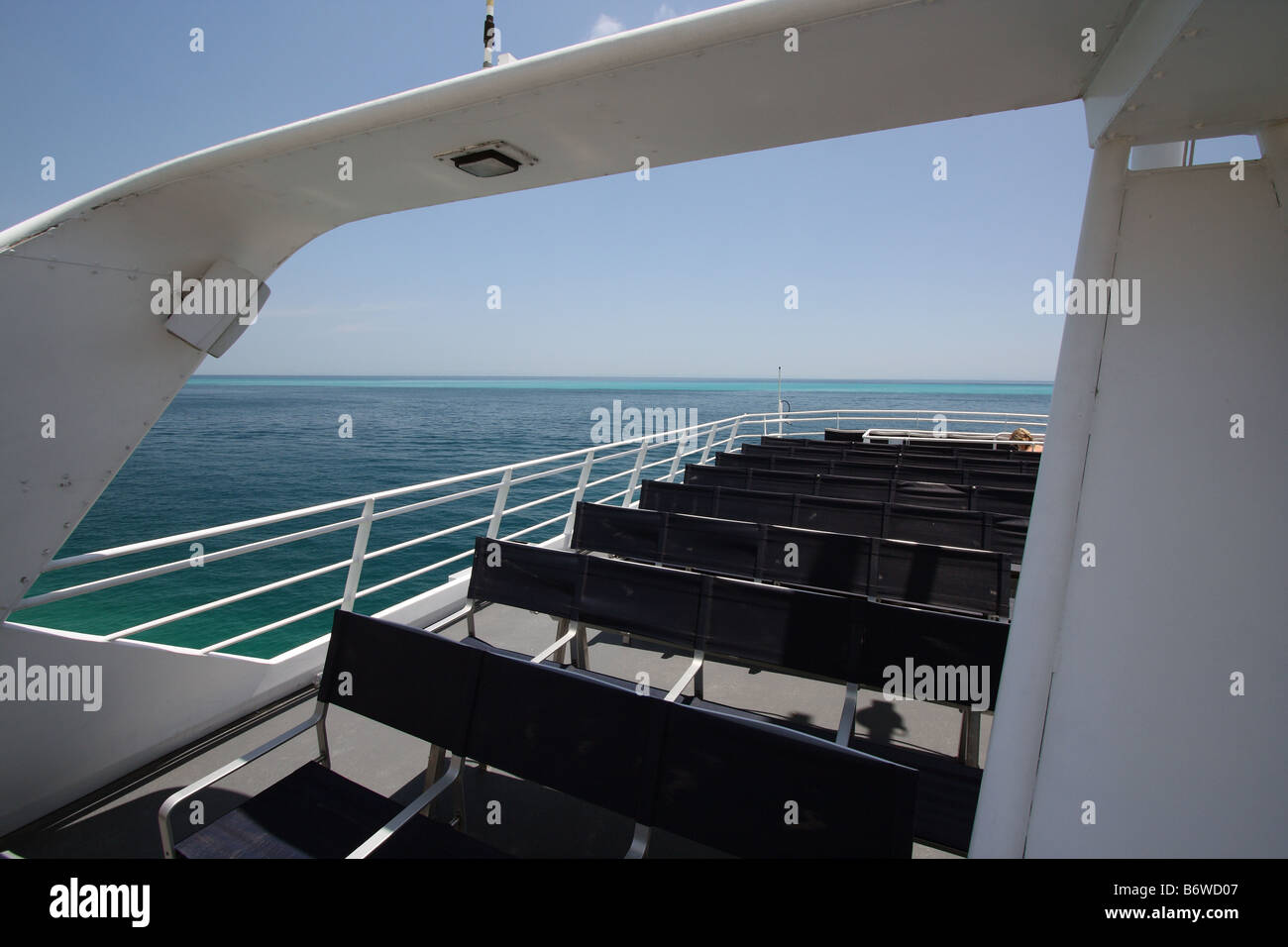 VIEW OF THE BACK OF A FERRY AS IT APPROACHES A TROPICAL ISLAND ...
