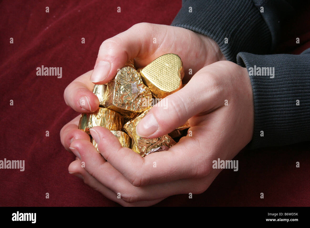 Hands with chocolates Stock Photo - Alamy