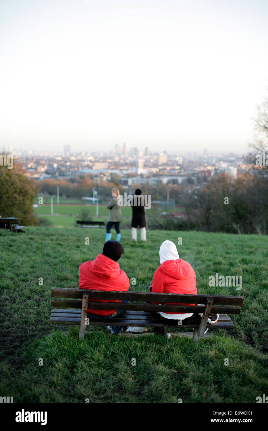 Two people sitting on a bench at the top of Parliament Hill, Hampstead ...