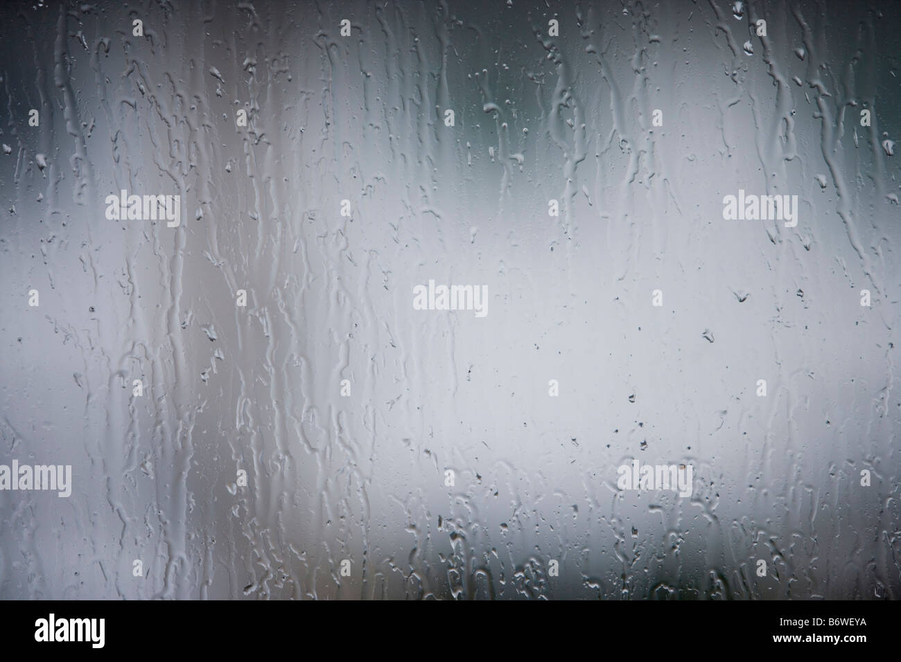 backdrop of raindrops running down a sheet of glass Stock Photo - Alamy