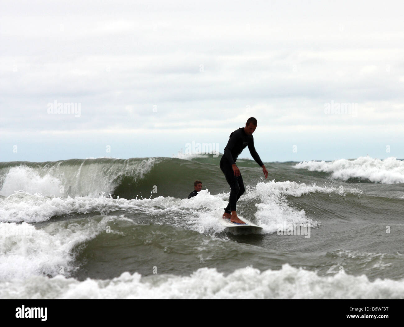 A pair of surfers out on a wavy day in Lake Michigan Stock Photo - Alamy