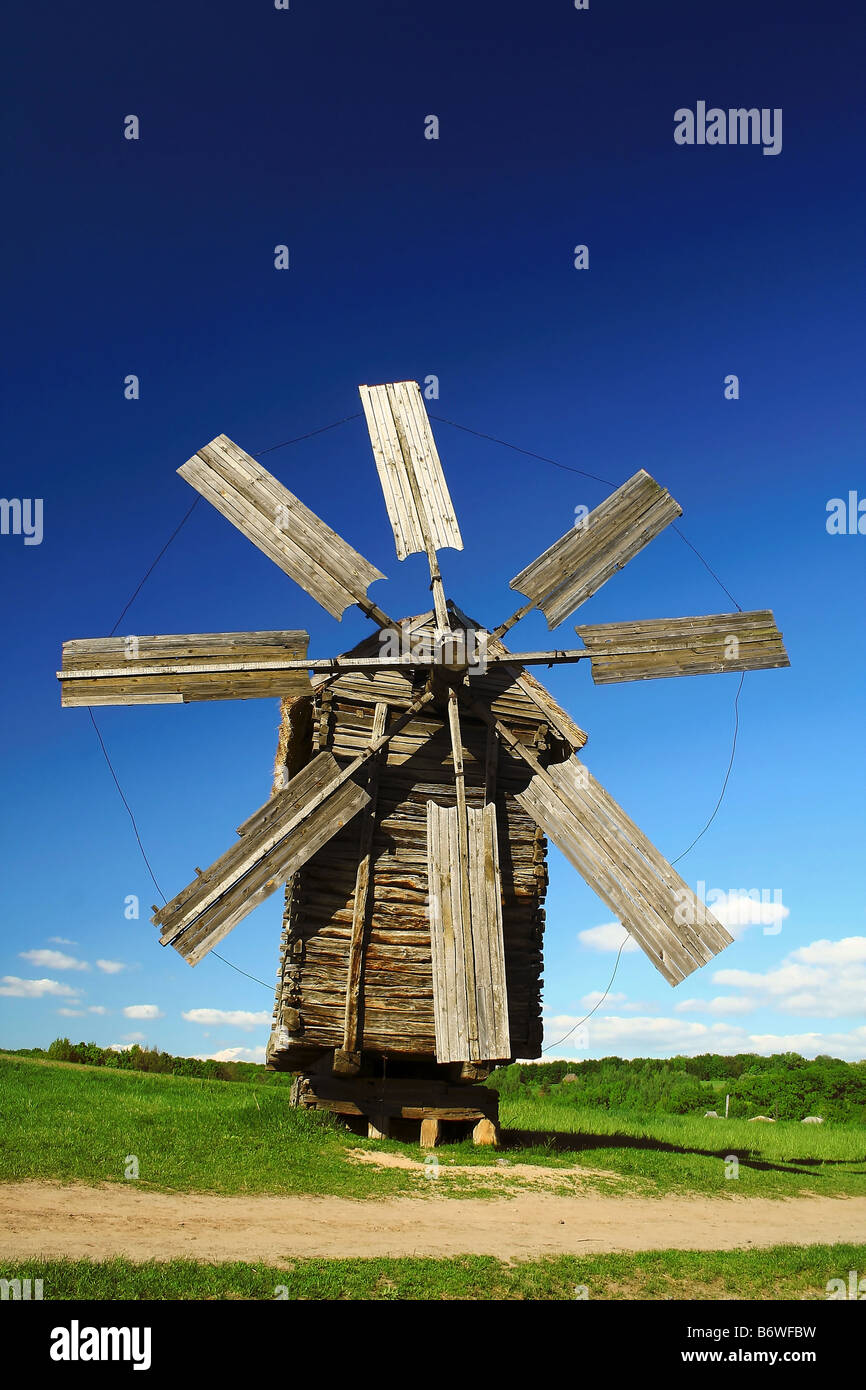 Windmill with straw roof on green meadow Stock Photo - Alamy
