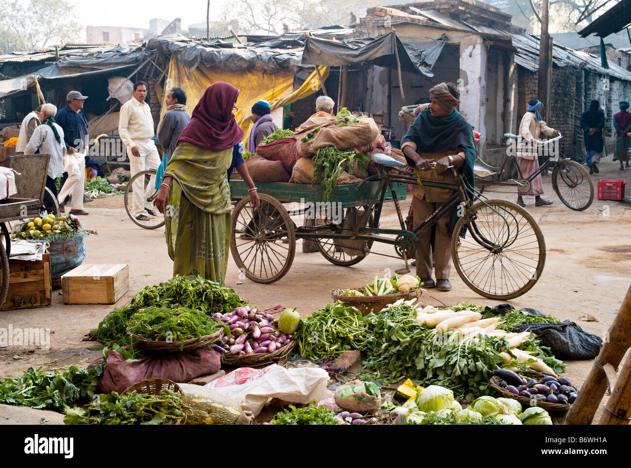 INDIA VARANASI Indian woman in colorful sari bargaining with bicycle ...