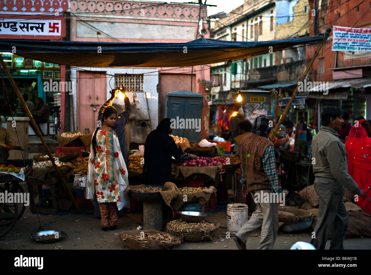 INDIA JAIPUR RAJASTHAN Vendors turn on the lights as night falls on the ...