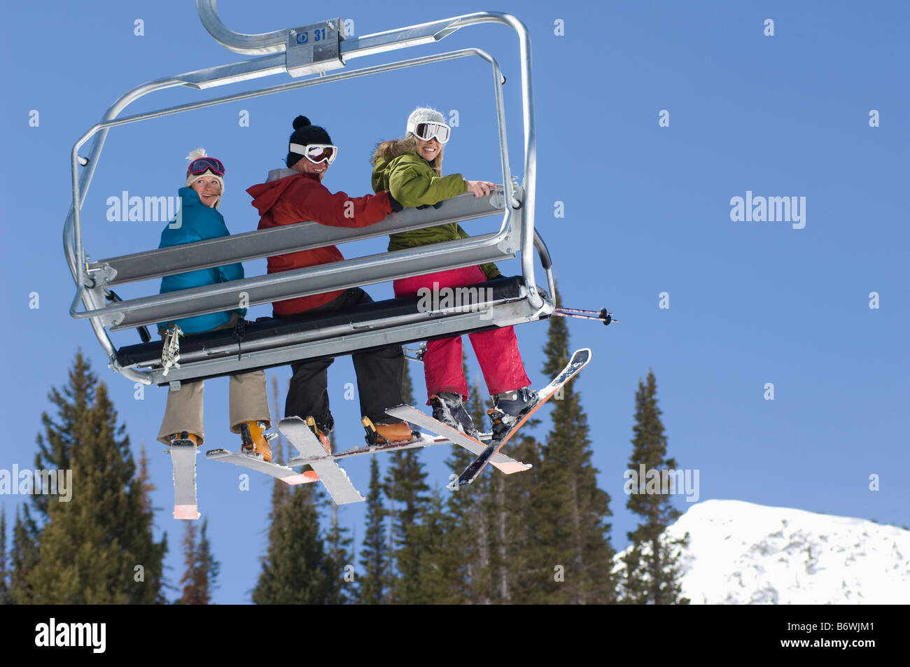 Three Skiers on Chair Lift Stock Photo - Alamy