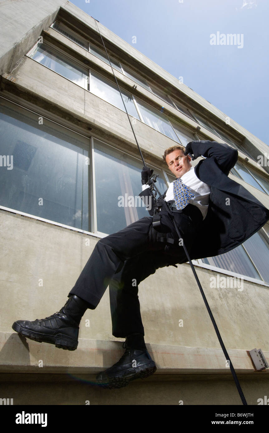 Spy Rappelling and Using Cell Phone Stock Photo - Alamy