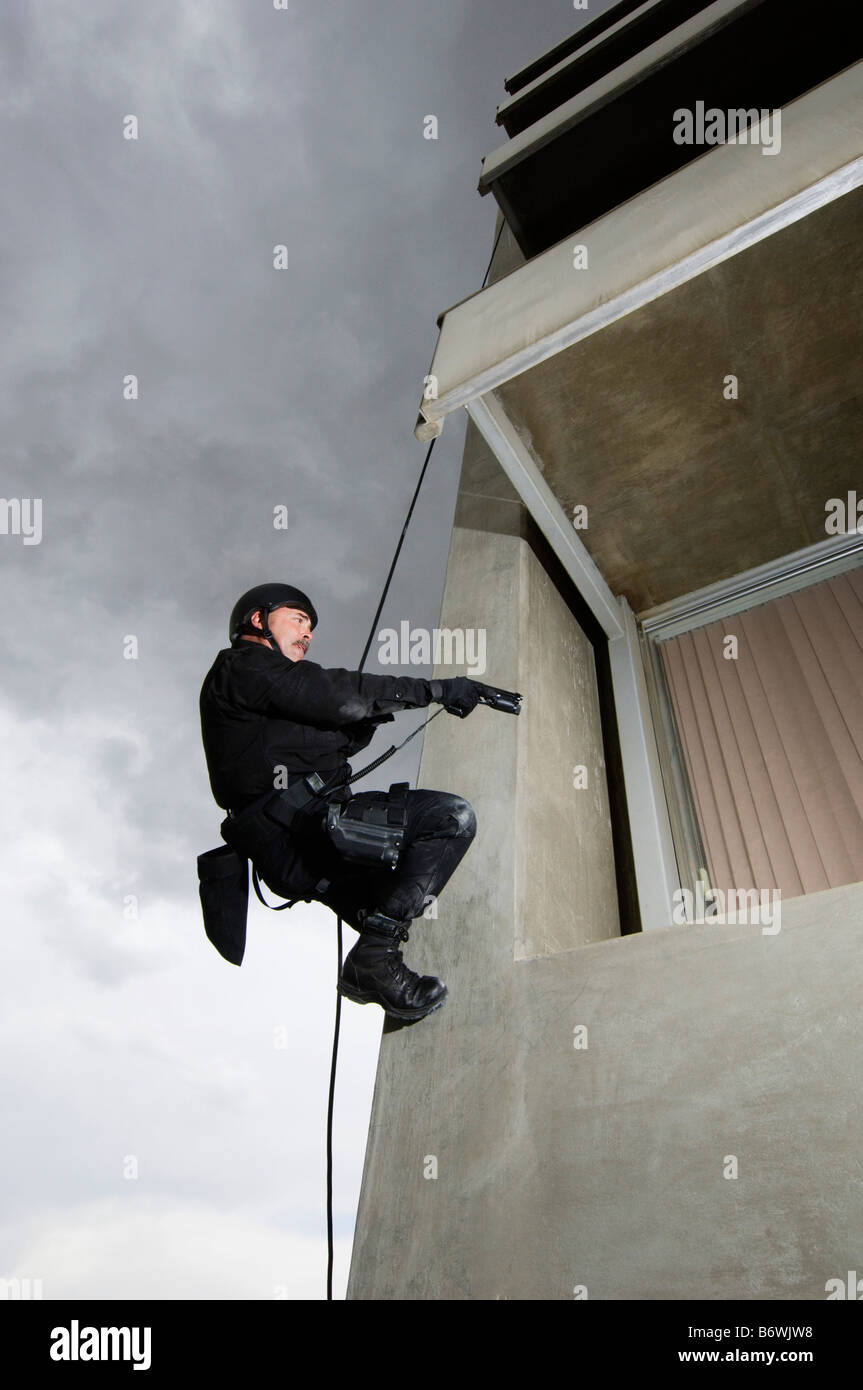 SWAT Team Officer Rappelling and Aiming Gun Stock Photo - Alamy