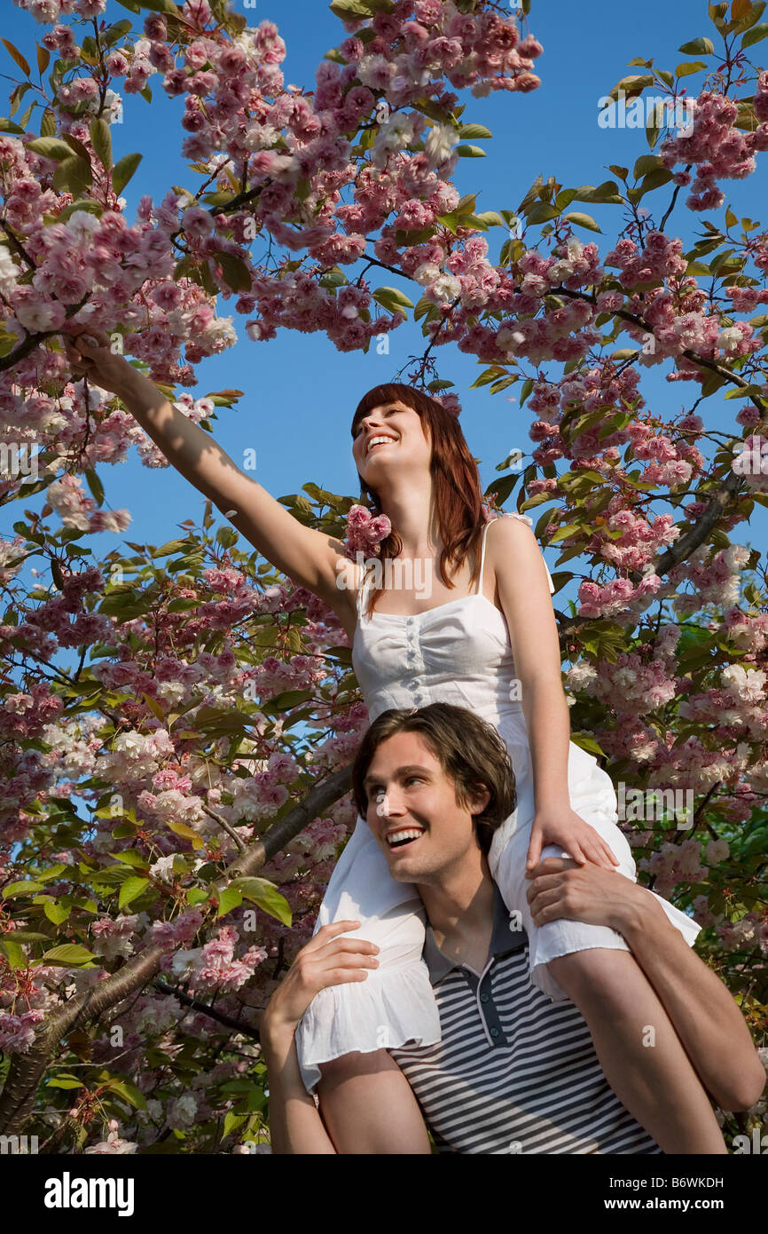 Young Man Lifting Woman up to Tree Branch Stock Photo - Alamy