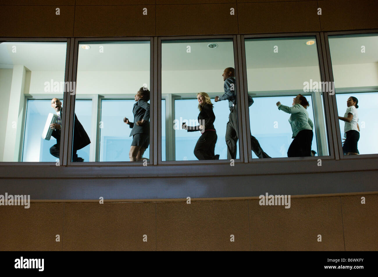 Businesspeople Running down Hallway Stock Photo - Alamy