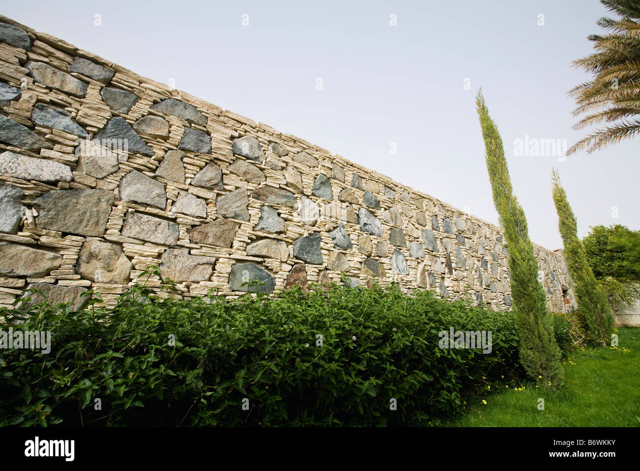 Hedge in Front of Stone Wall Stock Photo - Alamy
