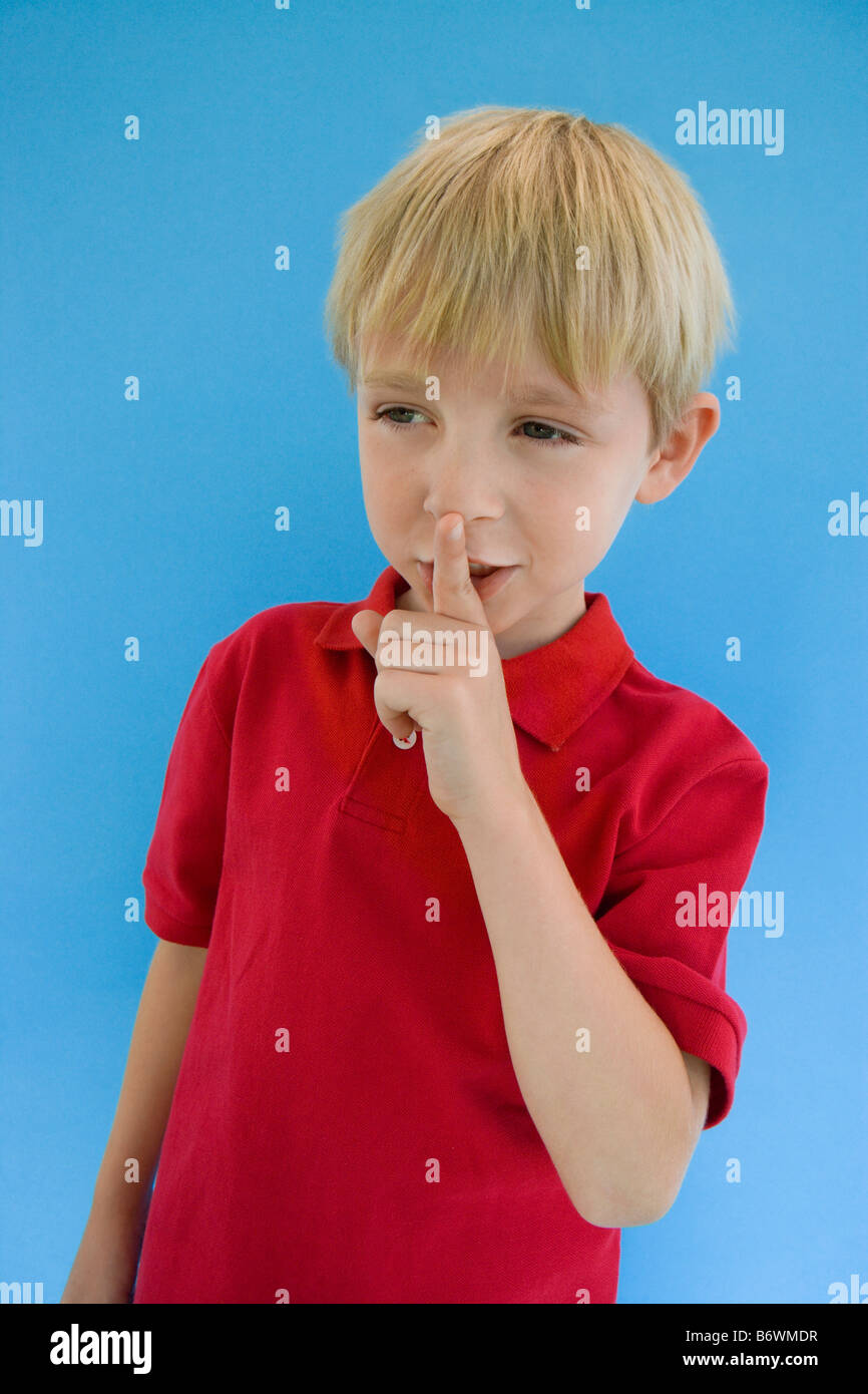 Boy with Finger on Lips Stock Photo - Alamy