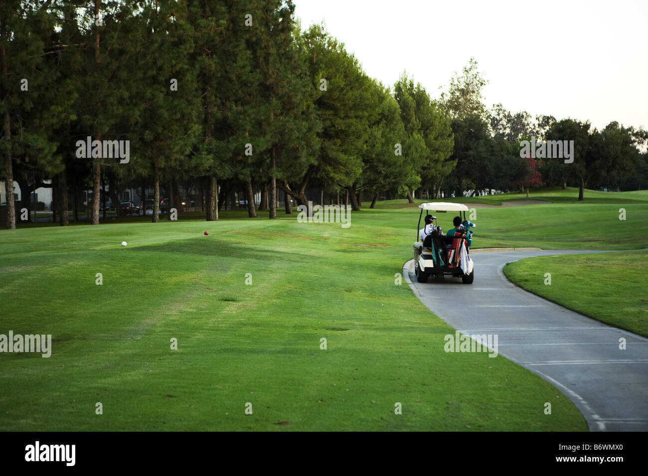 Two men and their clubs on golf cart Stock Photo - Alamy